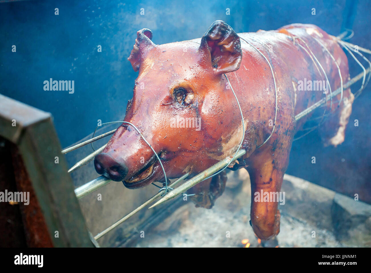 Whole pig roasting at open fire Stock Photo - Alamy