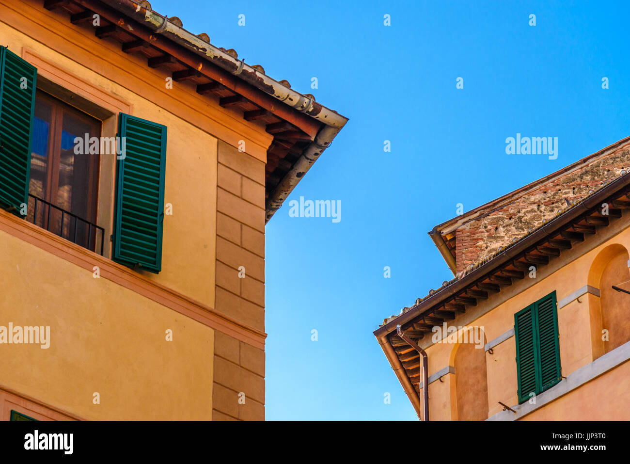 Overlapping of two tuscan building against blue sky Stock Photo - Alamy