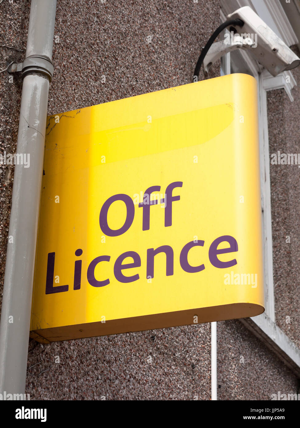 a yellow street and shop sign for the off licence; Essex; UK Stock ...