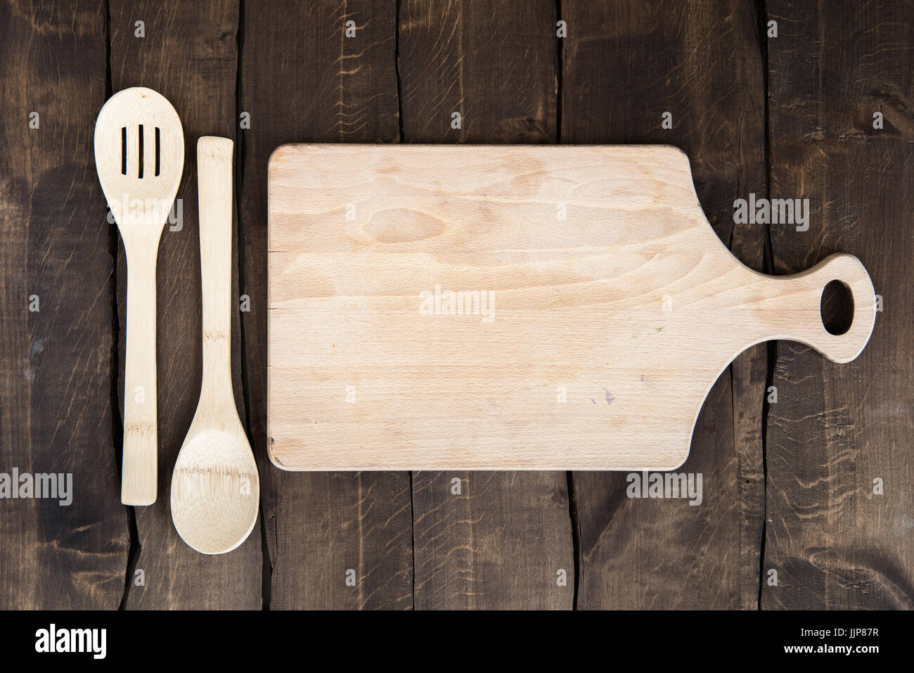 Top view of new wooden chopping board with kitchen utensils on wooden ...
