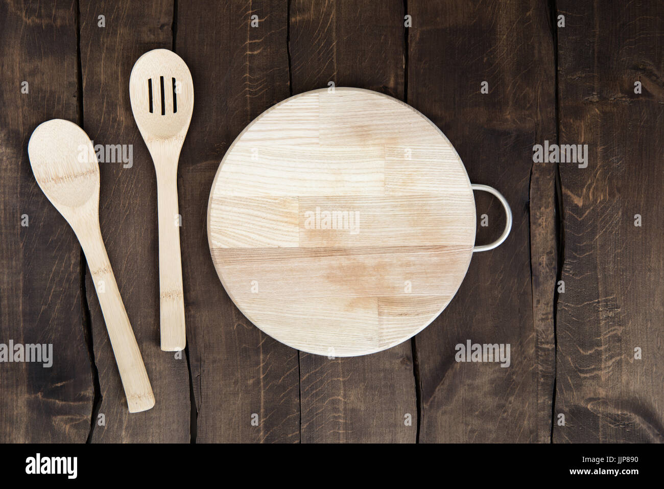 Overhead view of circular chopping board with kitchen utensils on ...