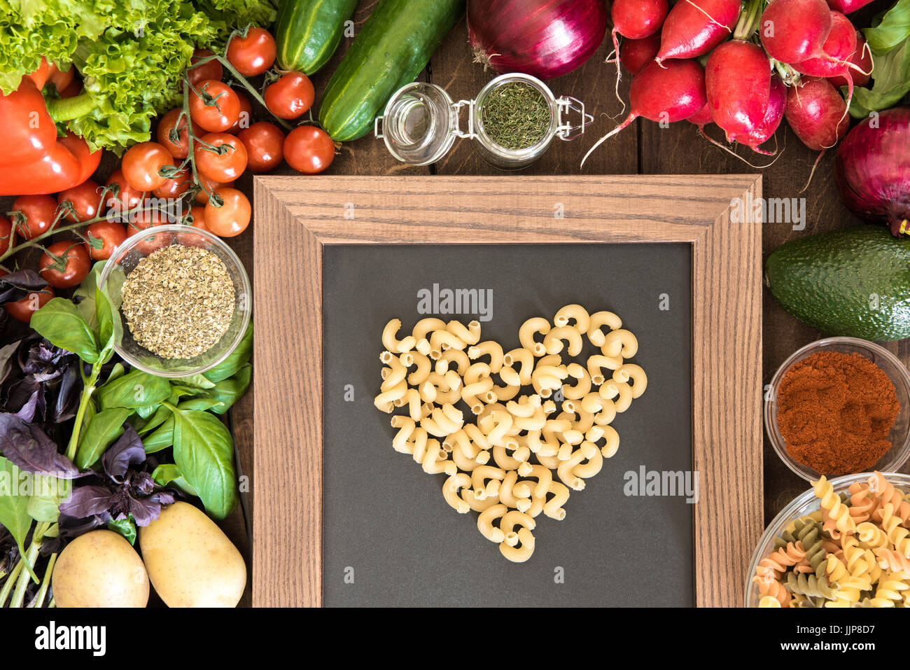 Cooking with love concept. Kitchen table full of vegetables, spices and ...