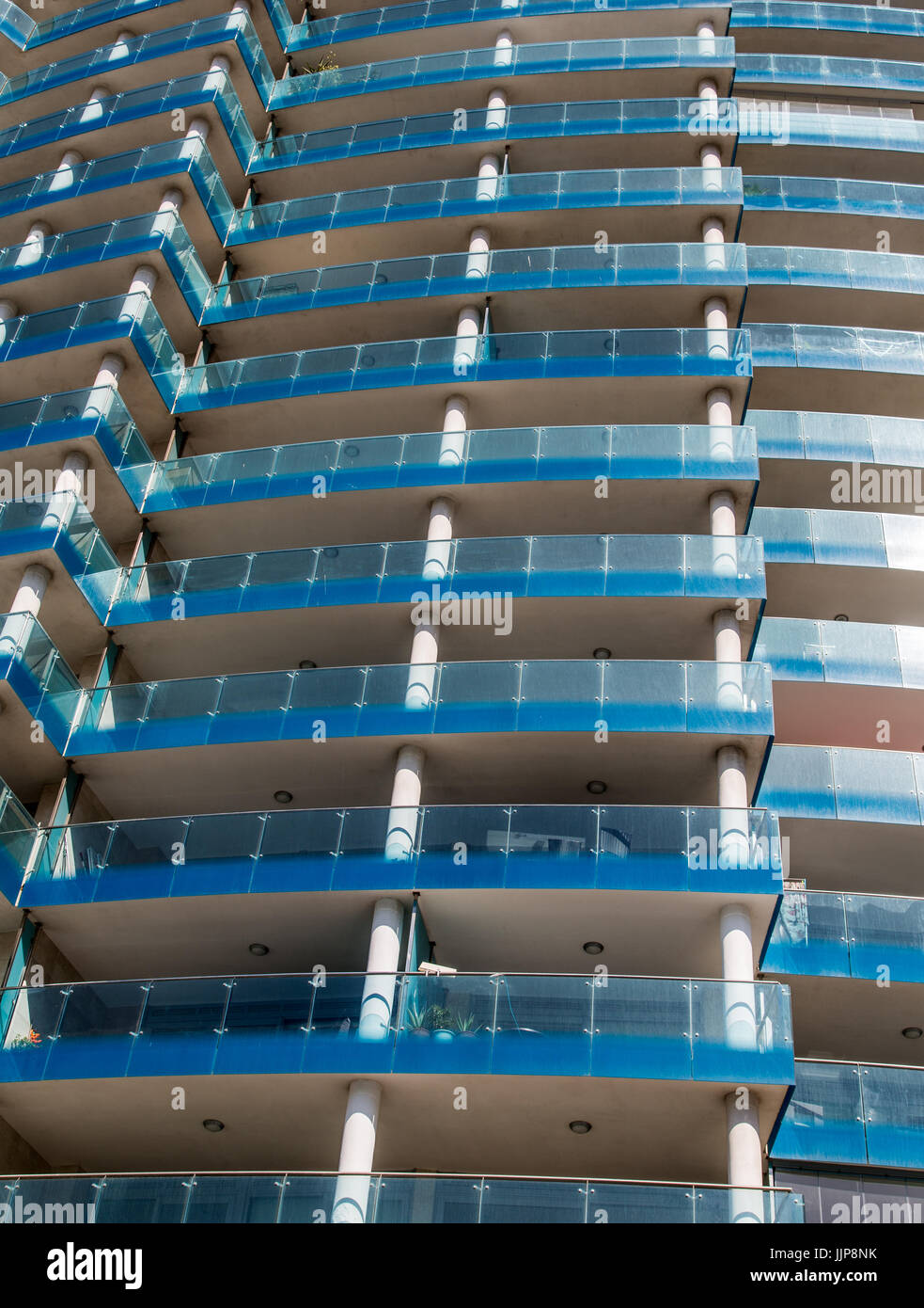 A blue glass high rise condo tower with balconies Stock Photo - Alamy