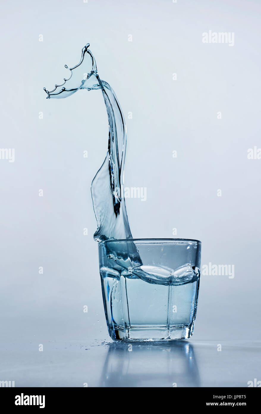 water splashing high out of glass isolated Stock Photo - Alamy