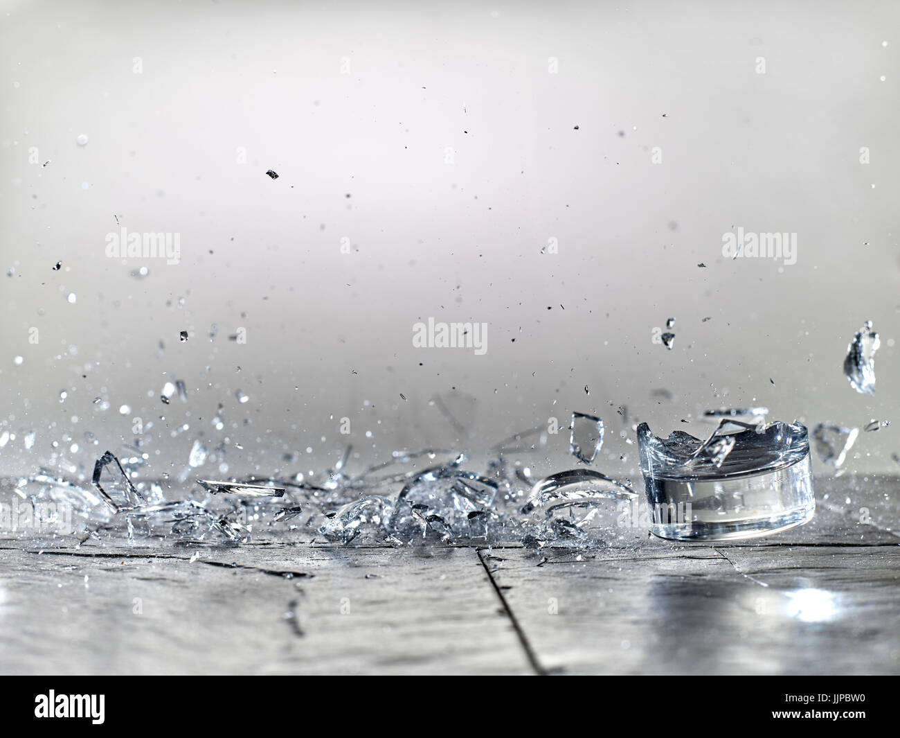 empty glass breaking on a stone floor Stock Photo - Alamy