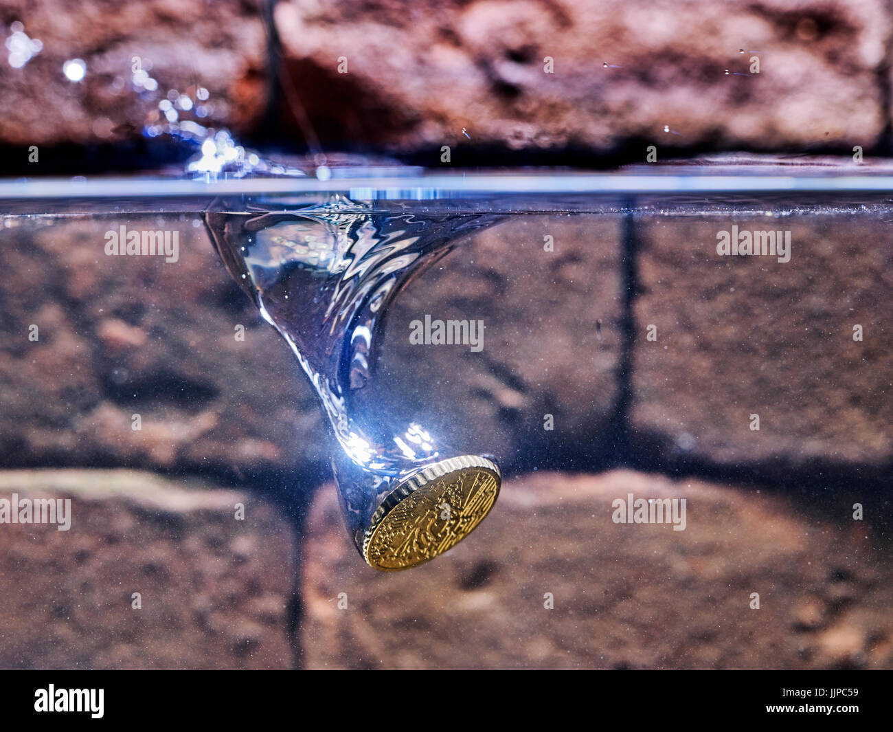 euro coin falling in a whising well Stock Photo - Alamy