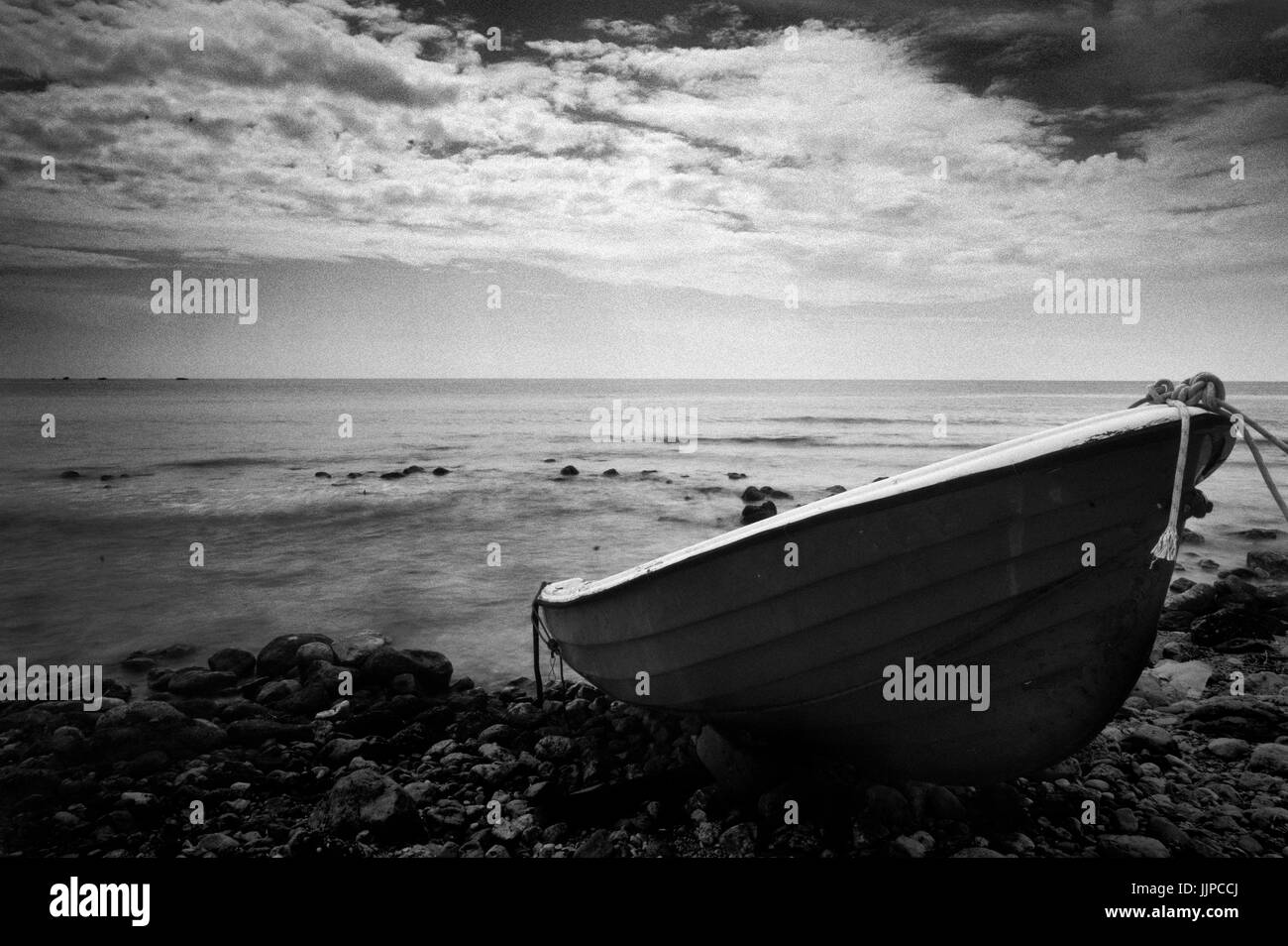 empty boat on a rock shore in black and white Stock Photo - Alamy
