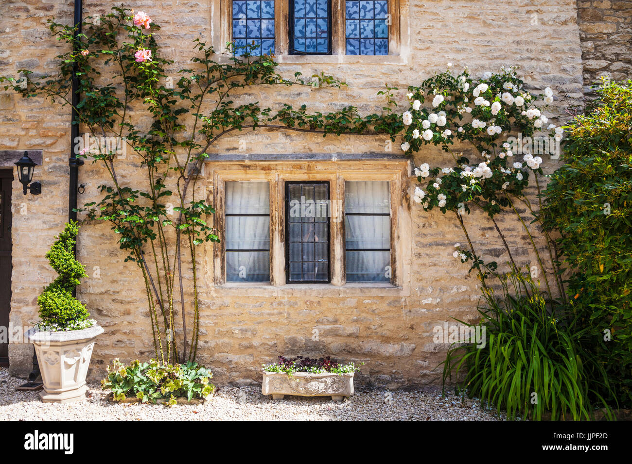 Cotswold stone house front with mullioned and leaded windows and ...