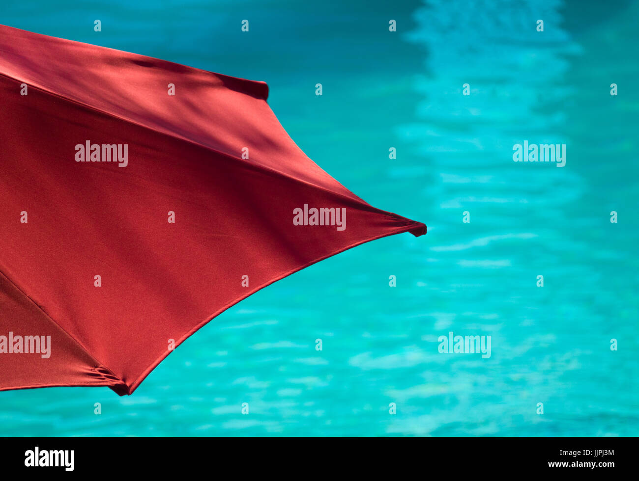 Red Parasol Beside Turquoise Swimming Pool Stock Photo - Alamy