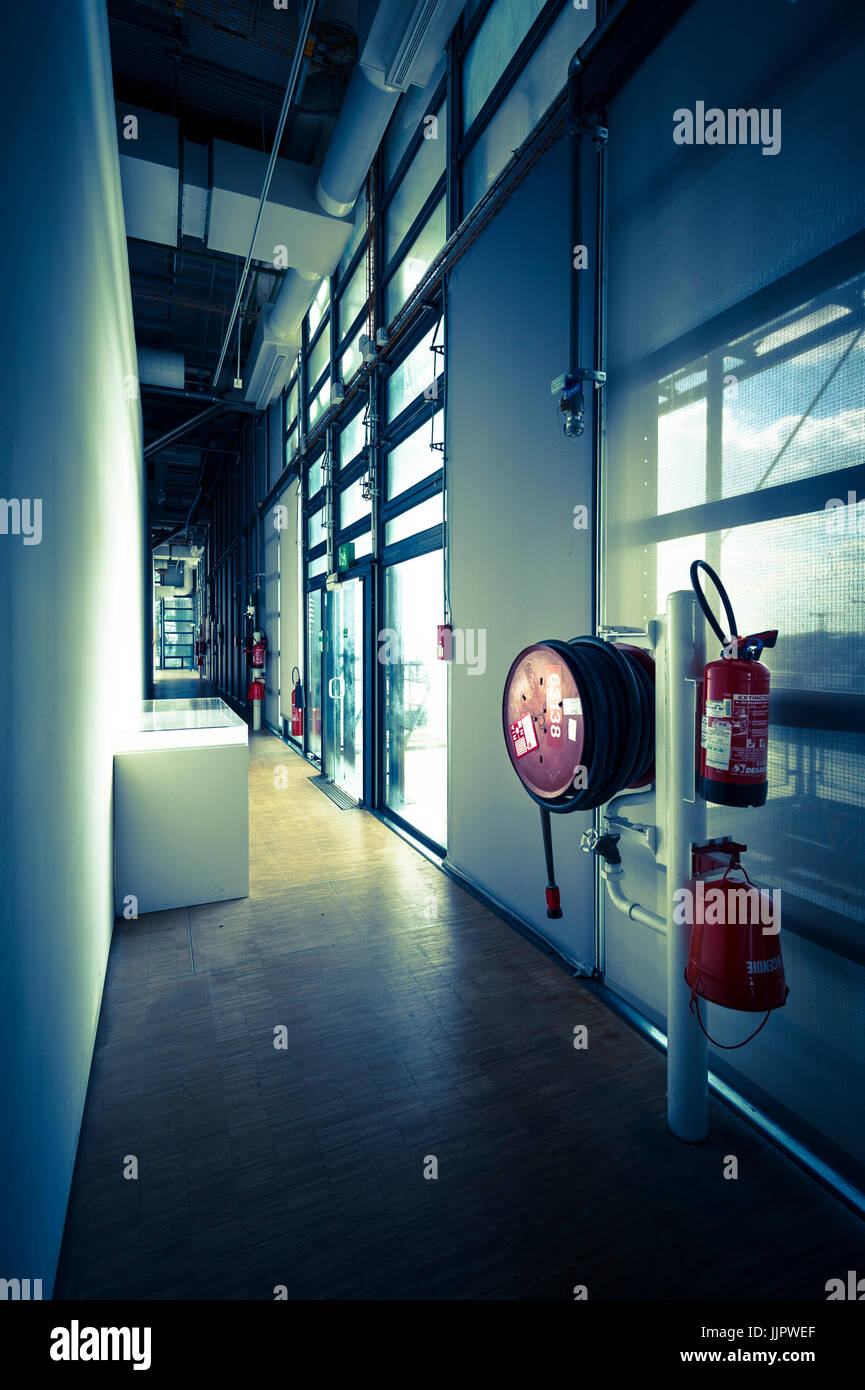 Emergency exit and a fire extinguisher in an industrial building Stock ...