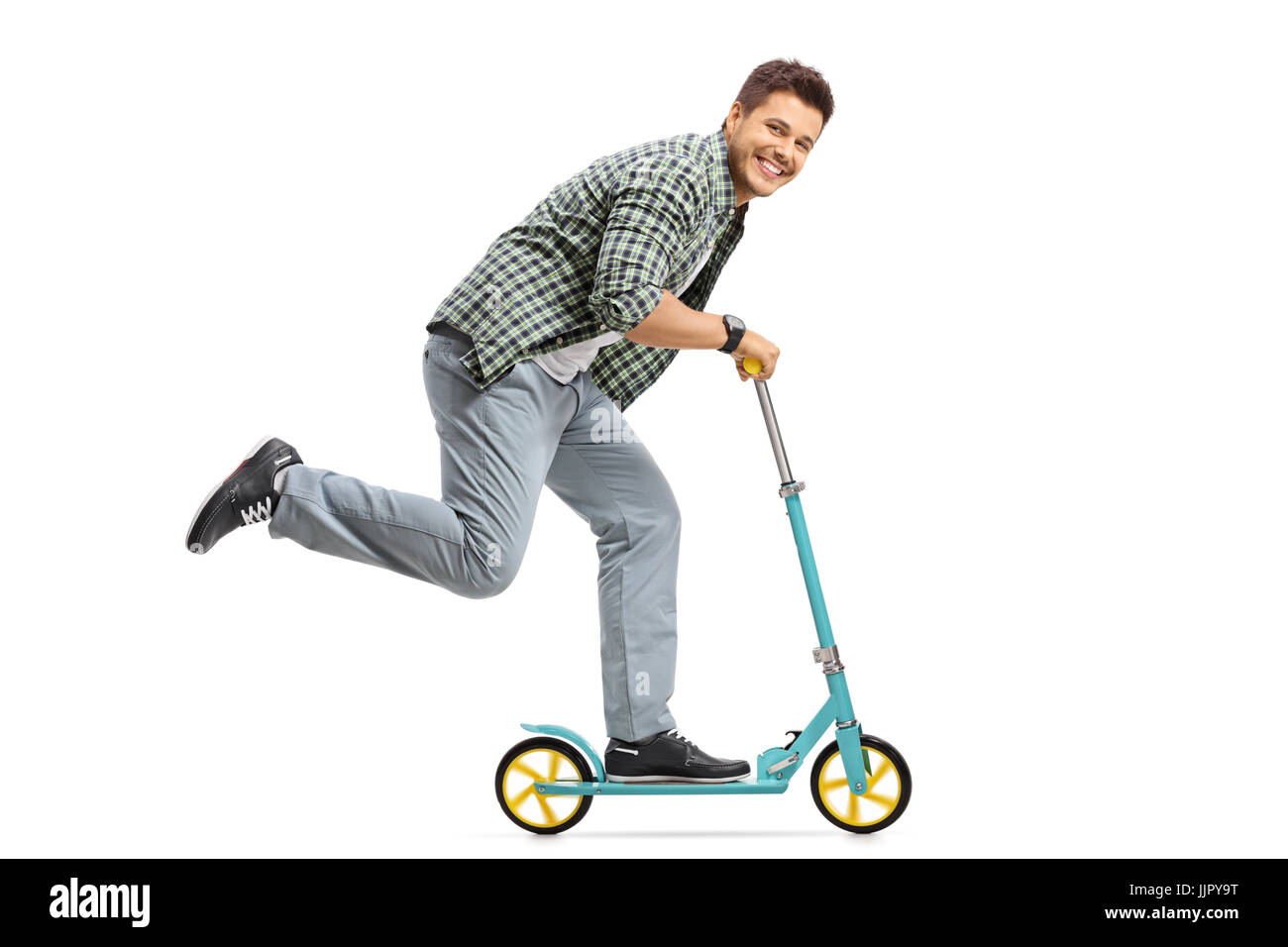 Young guy riding a scooter and looking at the camera isolated on white ...