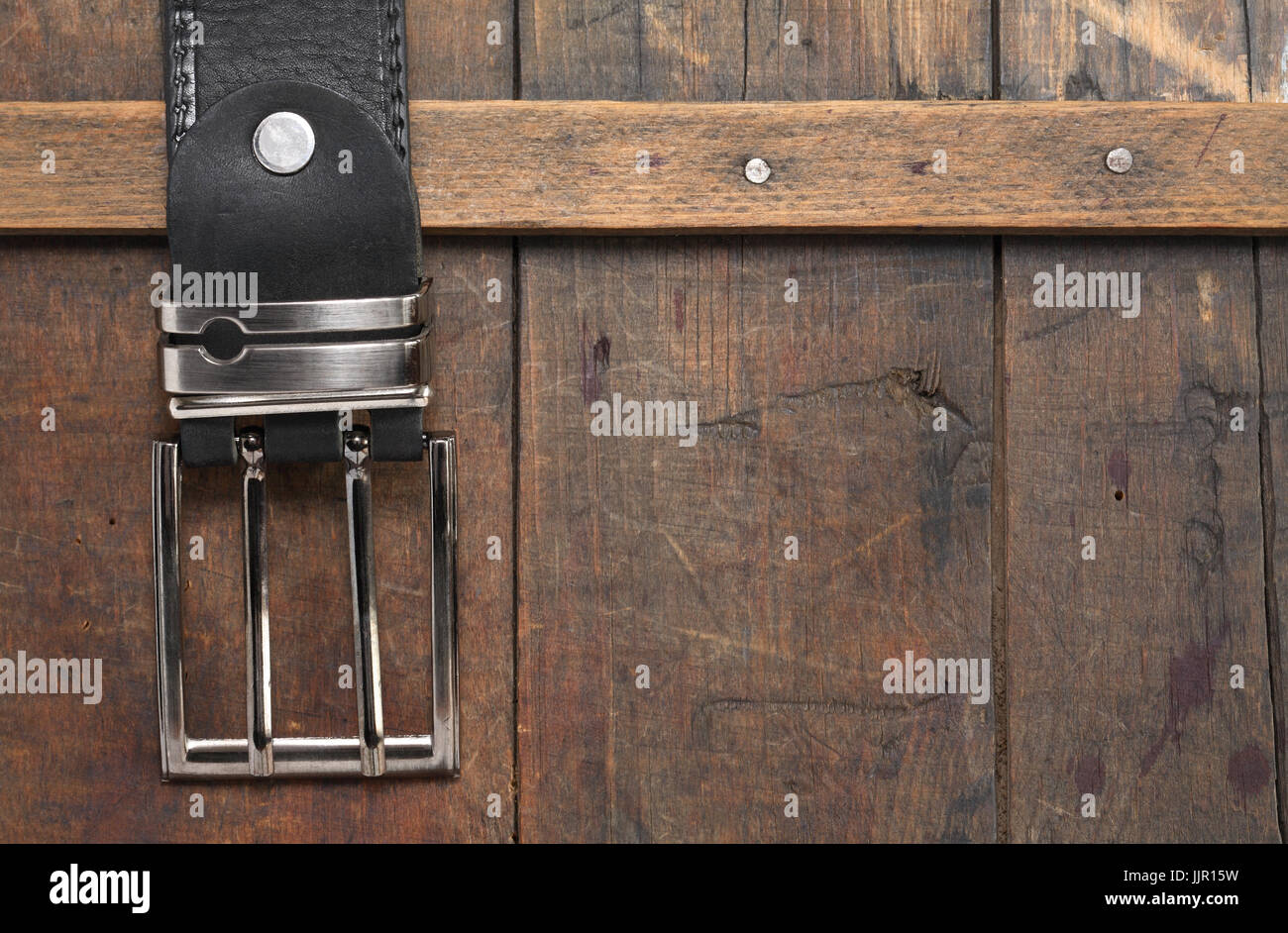 Closeup of black leather belt hanging on old wooden background Stock ...