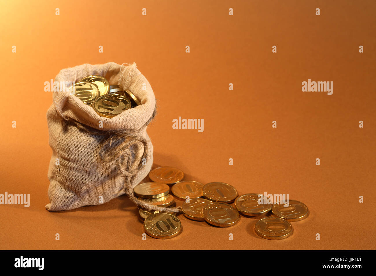 Wealth concept. Open burlap sack full of golden coins standing on ...