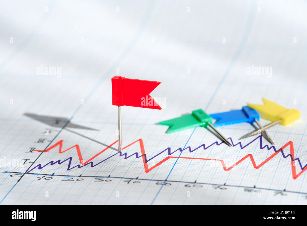 Red plastic flar pin attached to graph paper background with diagram ...