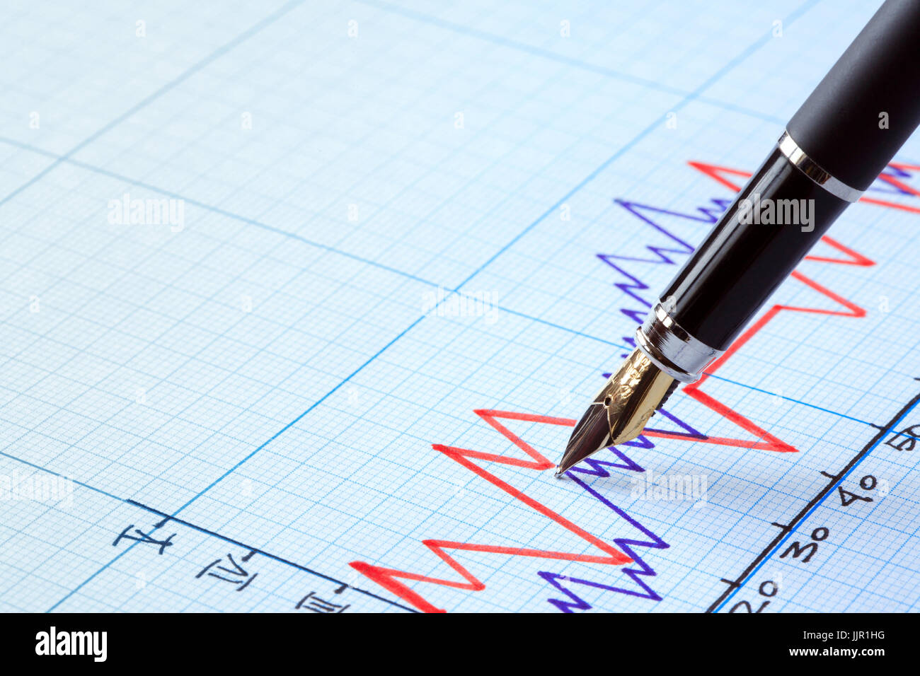 Business concept. Closeup of fountain pen on graph paper with diagram ...