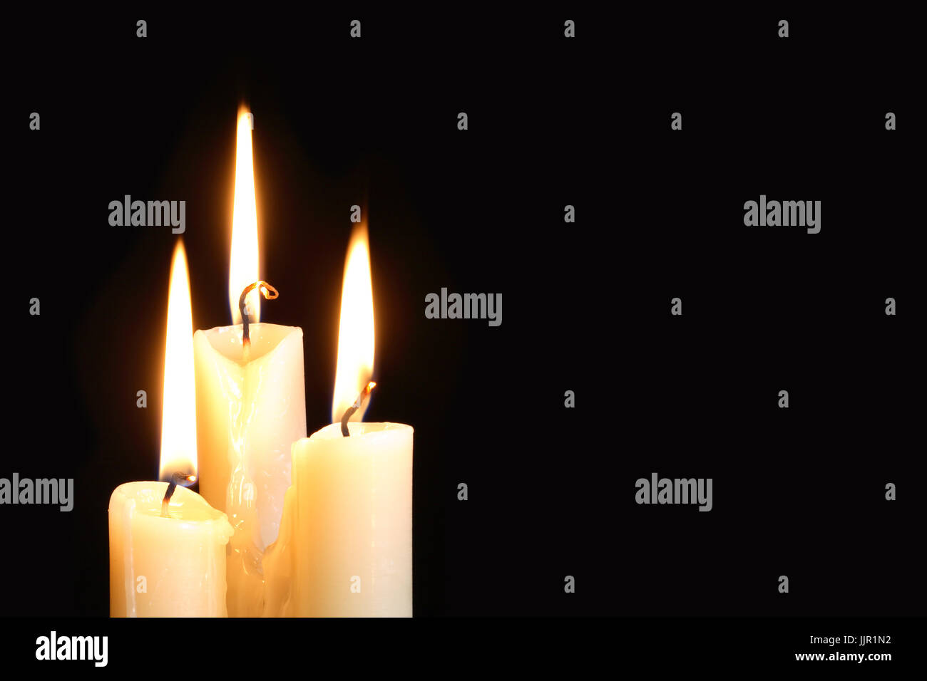 Three ordinary lighting candles on black background with free space for ...