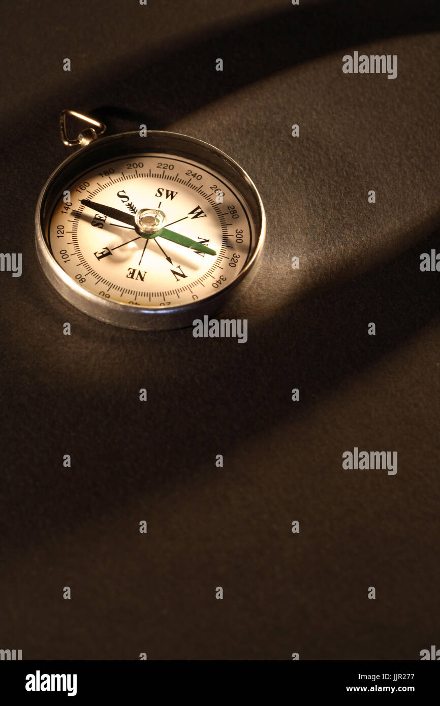 Vintage compass under beam of light on dark background Stock Photo - Alamy