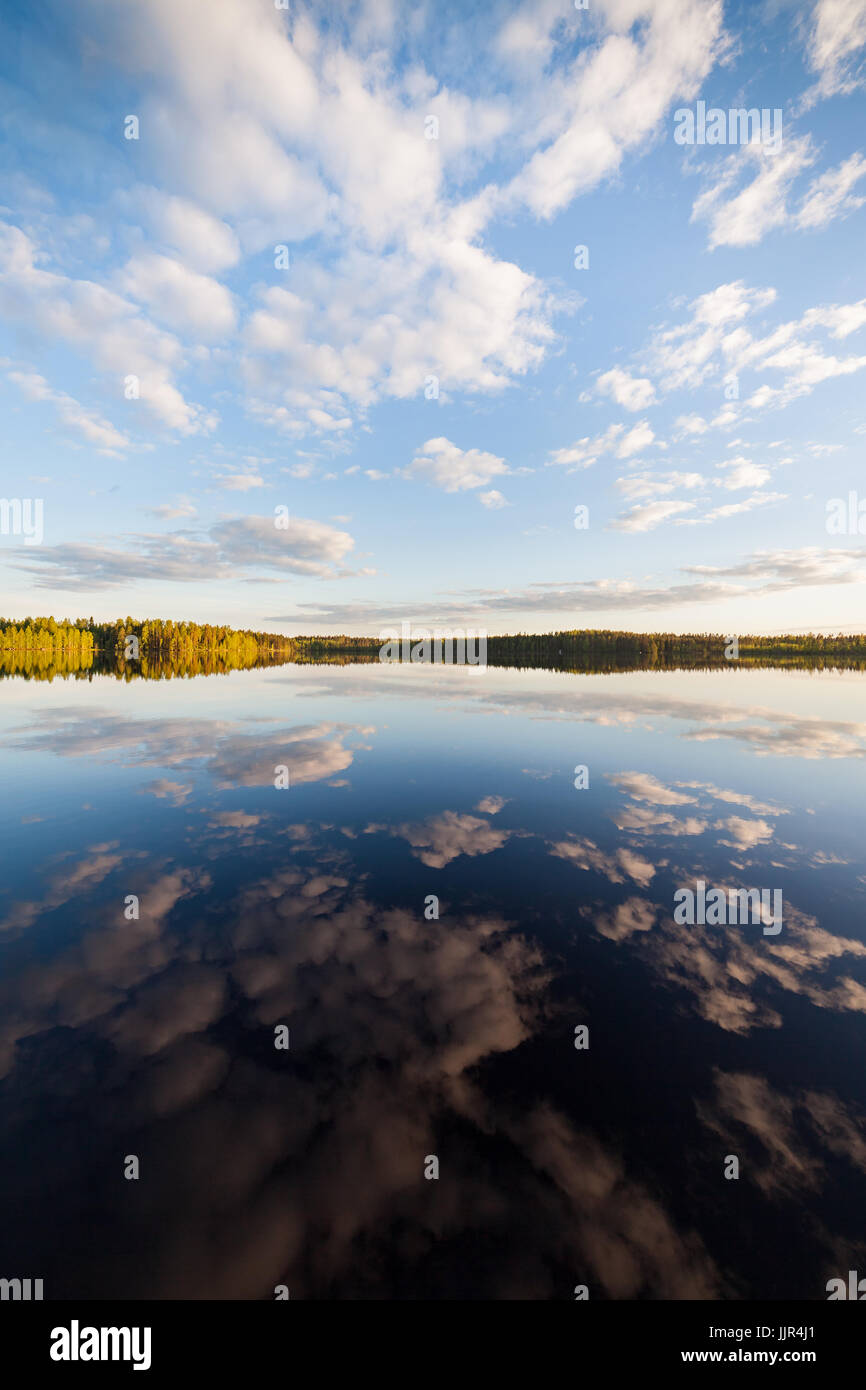 Still lake perfect reflection of sky and clouds Stock Photo - Alamy