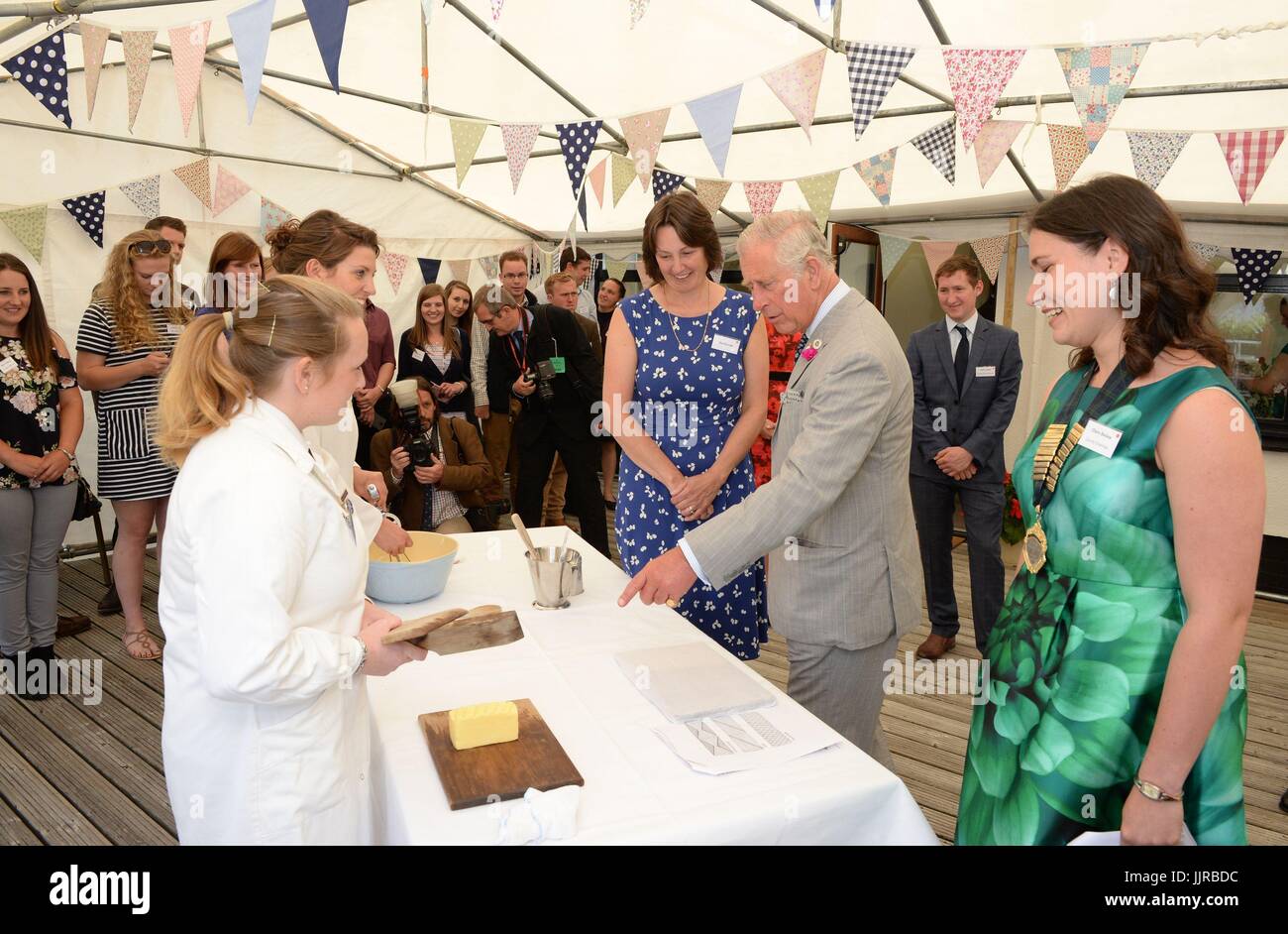 The Prince of Wales observes the process of handcrafted butter at the ...