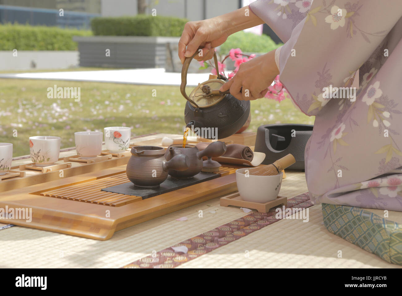 japanese woman pouring tea in the sakura zen garden Stock Photo - Alamy