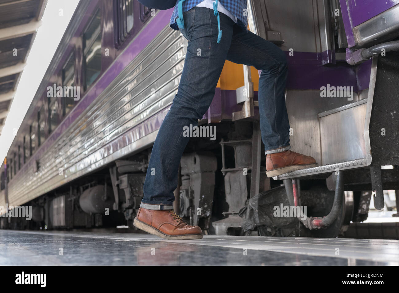 feet of young man, tourist or traveler stepping up to the train on ...
