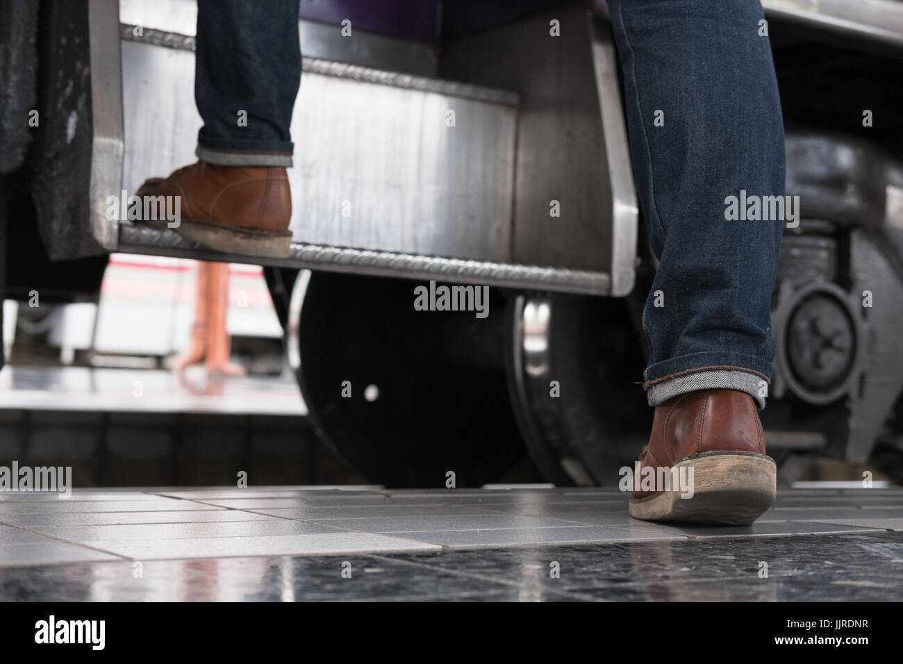 feet of young man, tourist or traveler stepping up to the train on ...