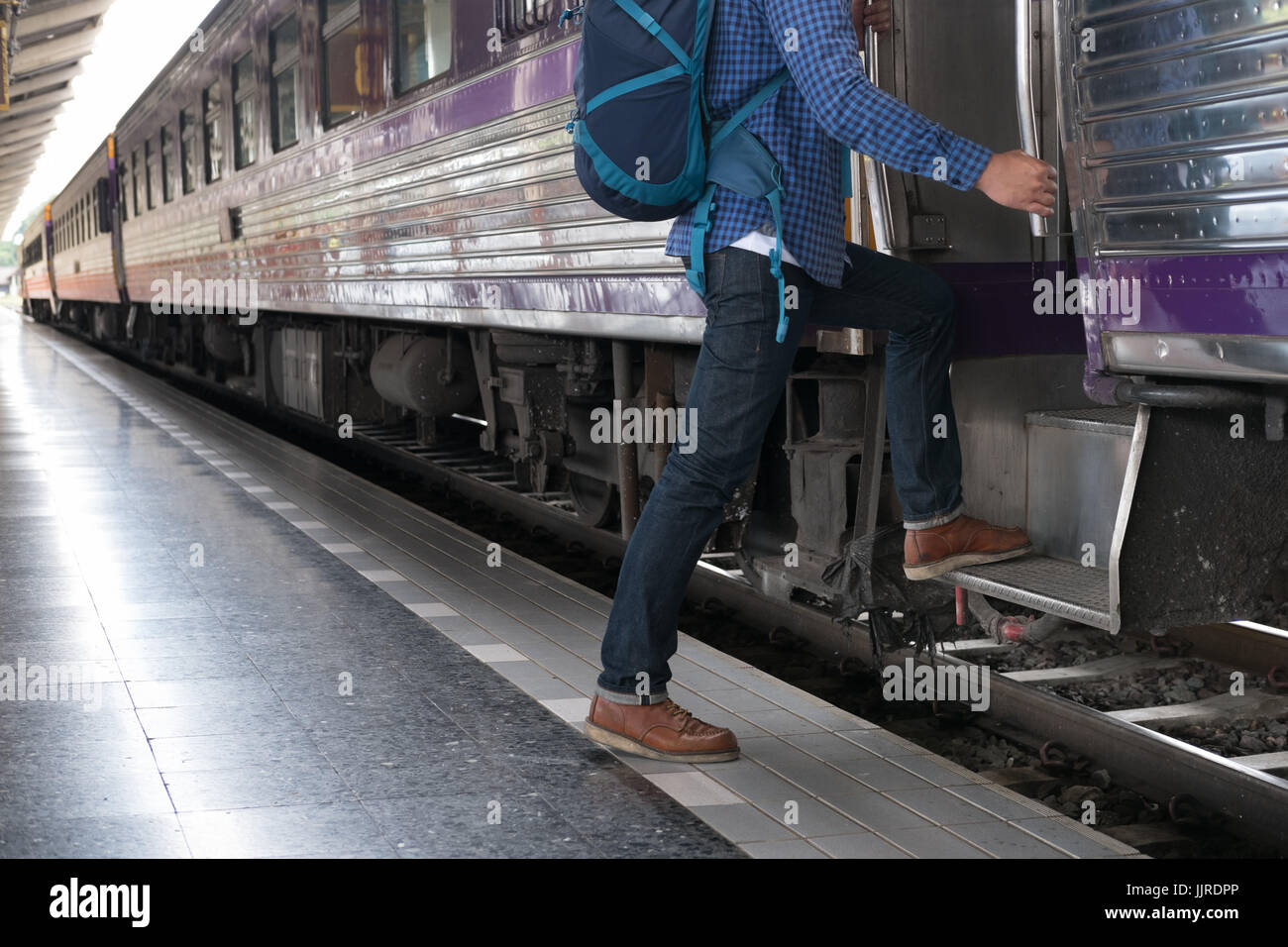 feet of young man, tourist or traveler stepping up to the train on ...