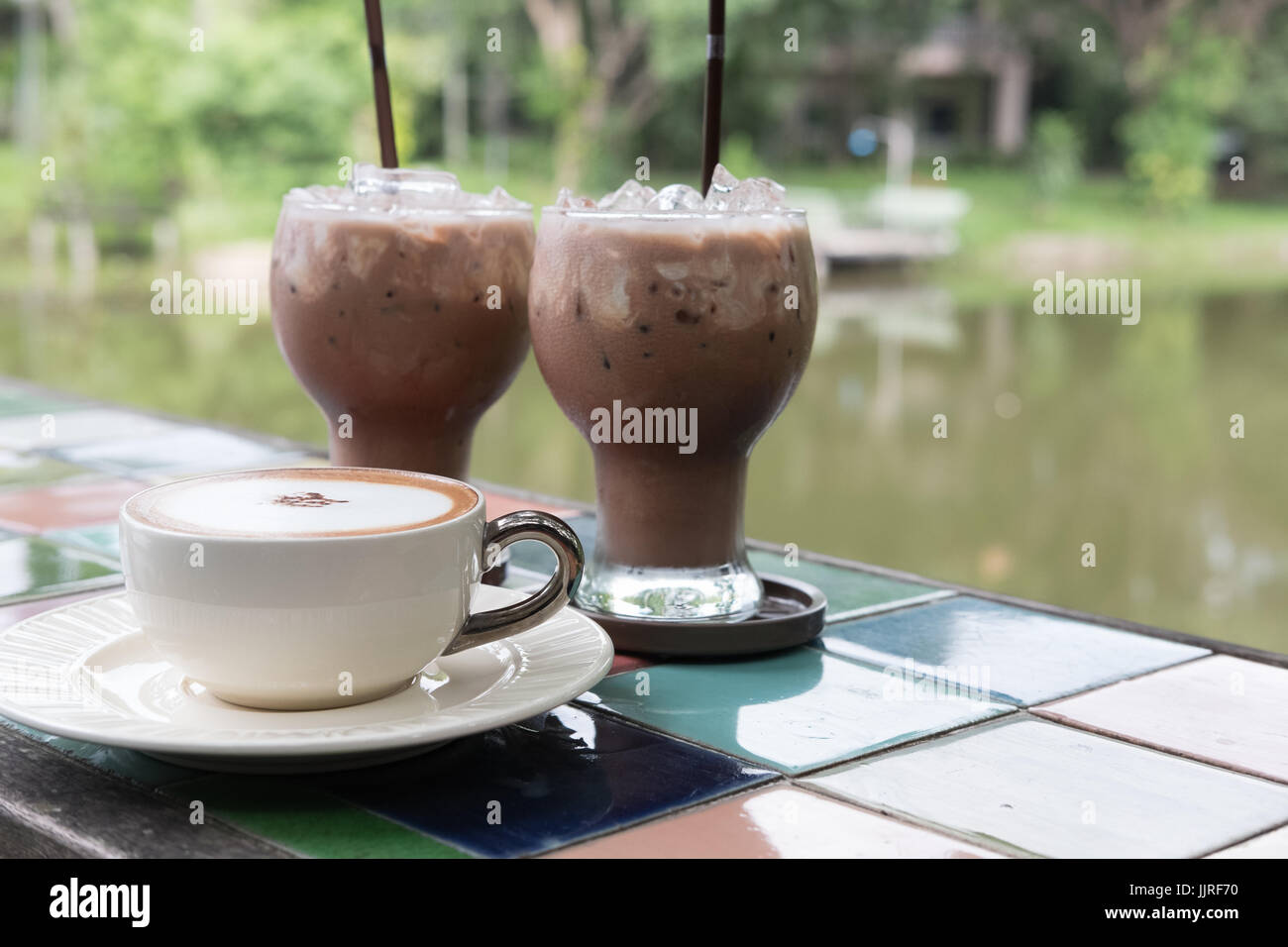 hot cappuccino coffee cup and two iced chocolate cocoa drink in the ...