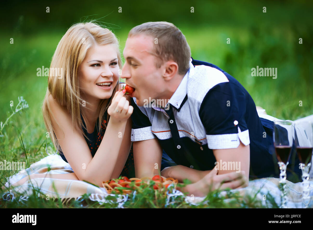 girl feeding the guy a strawberry. Beautiful healthy young girlfriend ...