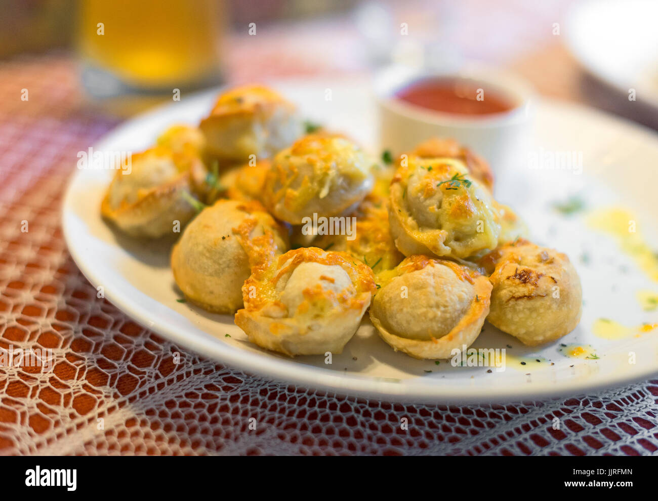 Traditional Russian pelmeni with cheese and tomato sauce Stock Photo ...