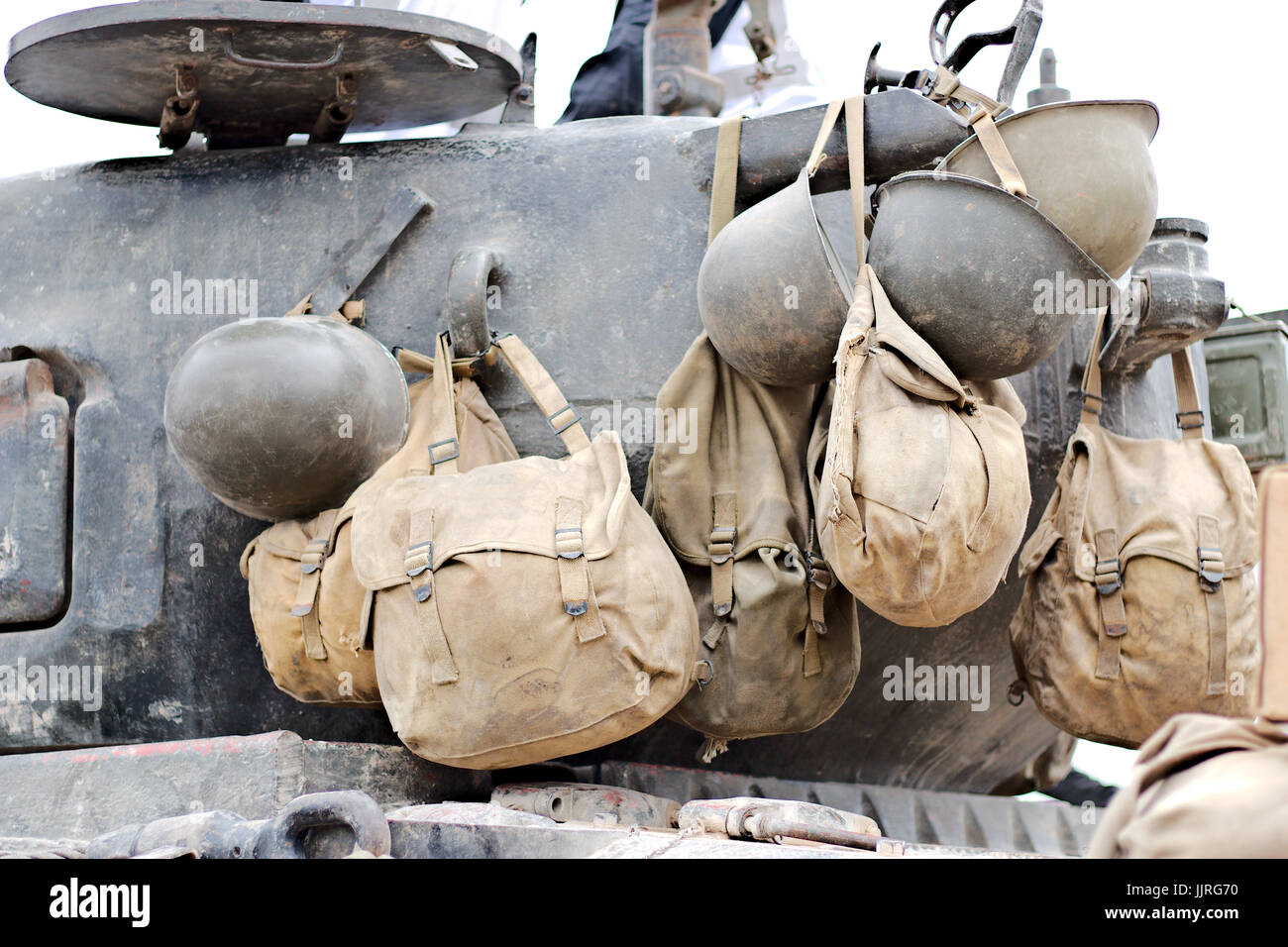 An assortment of WW2 American helmets and kit bags hanging from side of ...