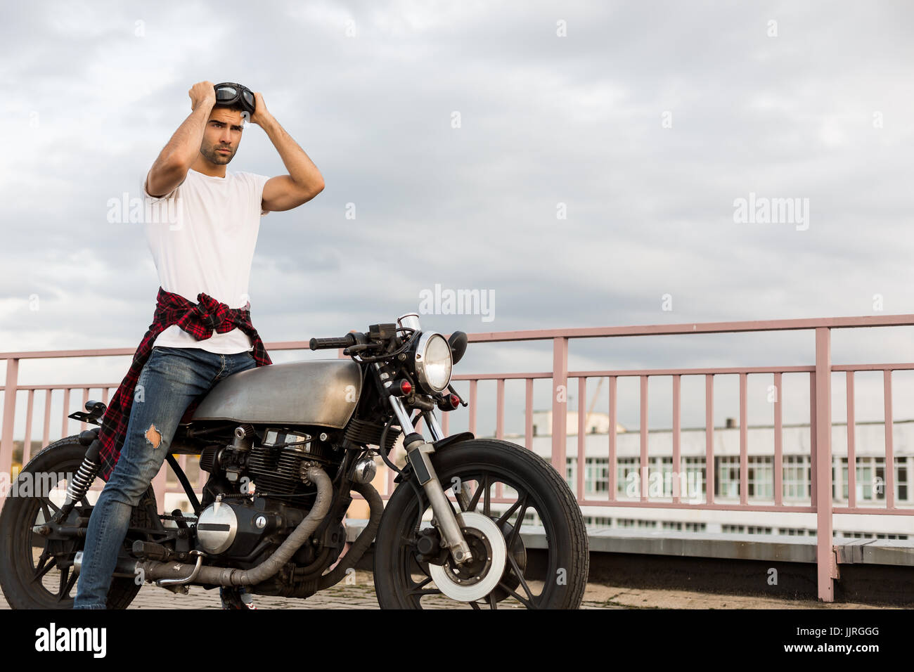 Handsome rider guy with beard and mustache put on protection glasses ...