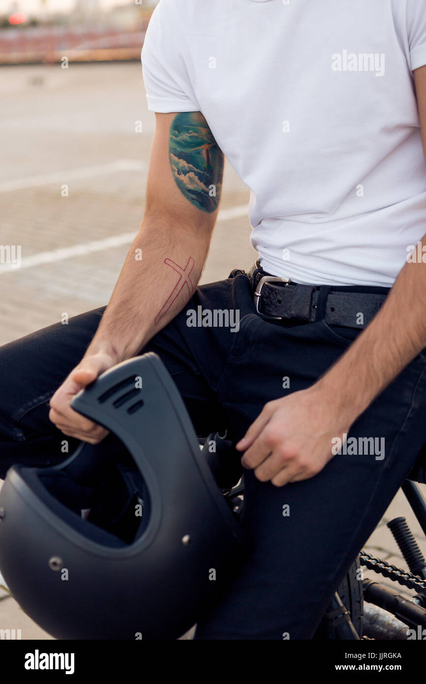 Close up of a handsome rider man in white blank t-shirt with helmet ...
