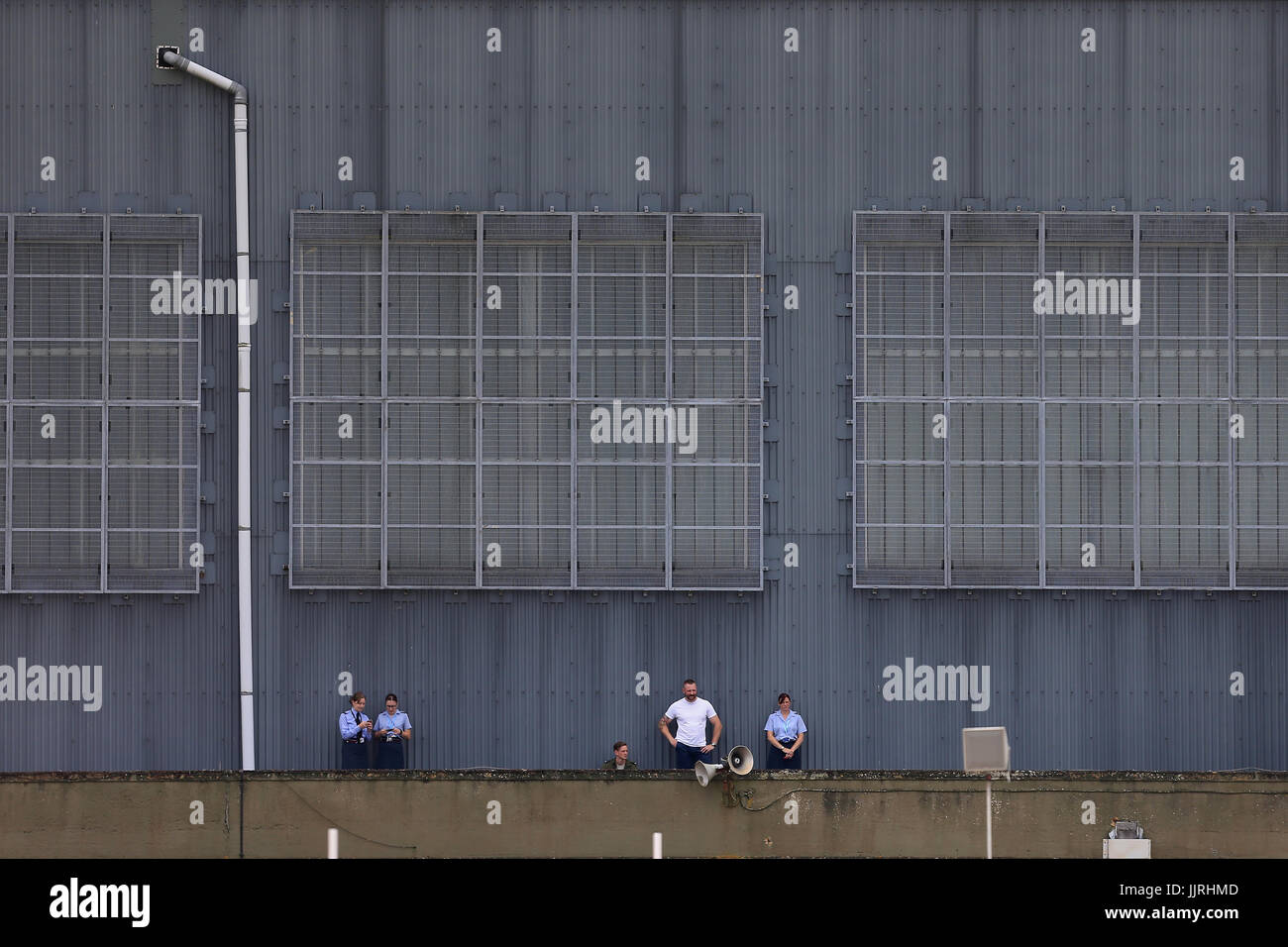 Staff look on from a building as airmen march at RAF Honington in ...