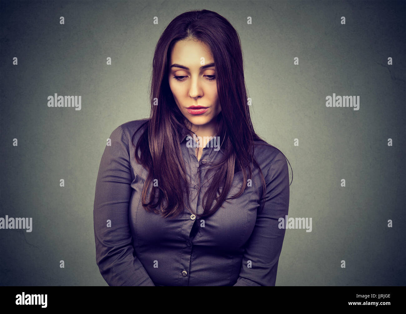 Sad young woman looking down Stock Photo - Alamy