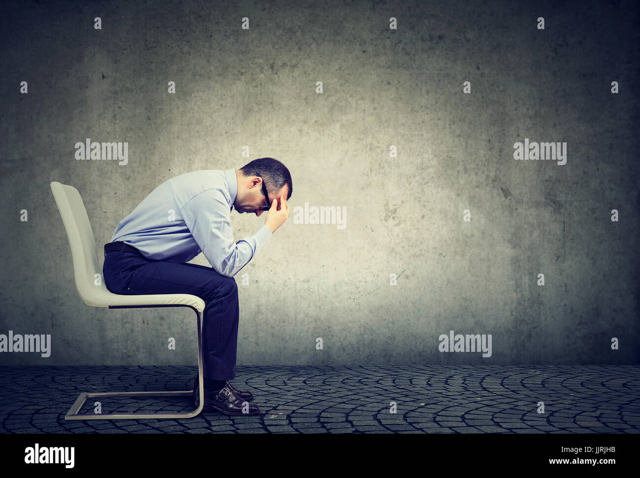 Sad stressed businessman sitting in an empty office Stock Photo - Alamy