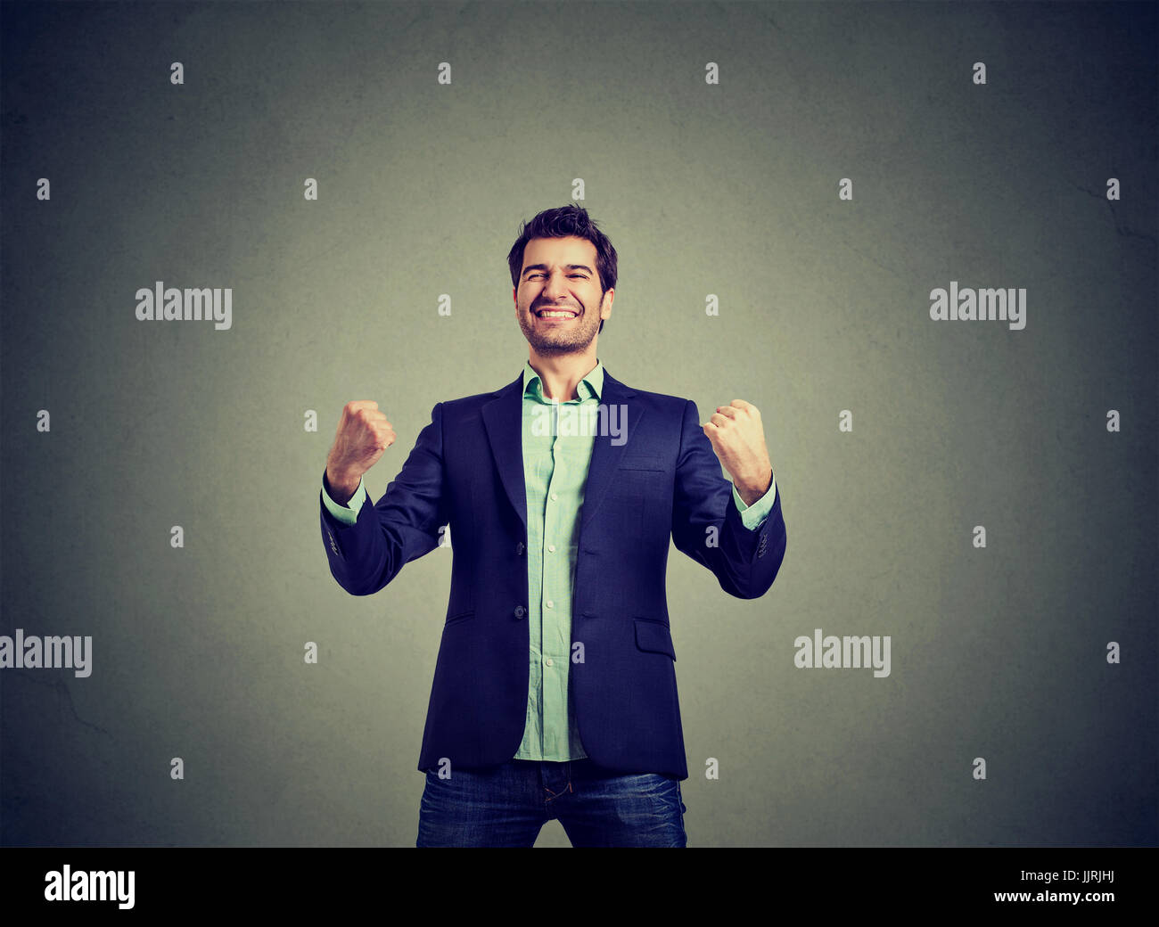 Successful business man winning celebrating success isolated gray wall ...