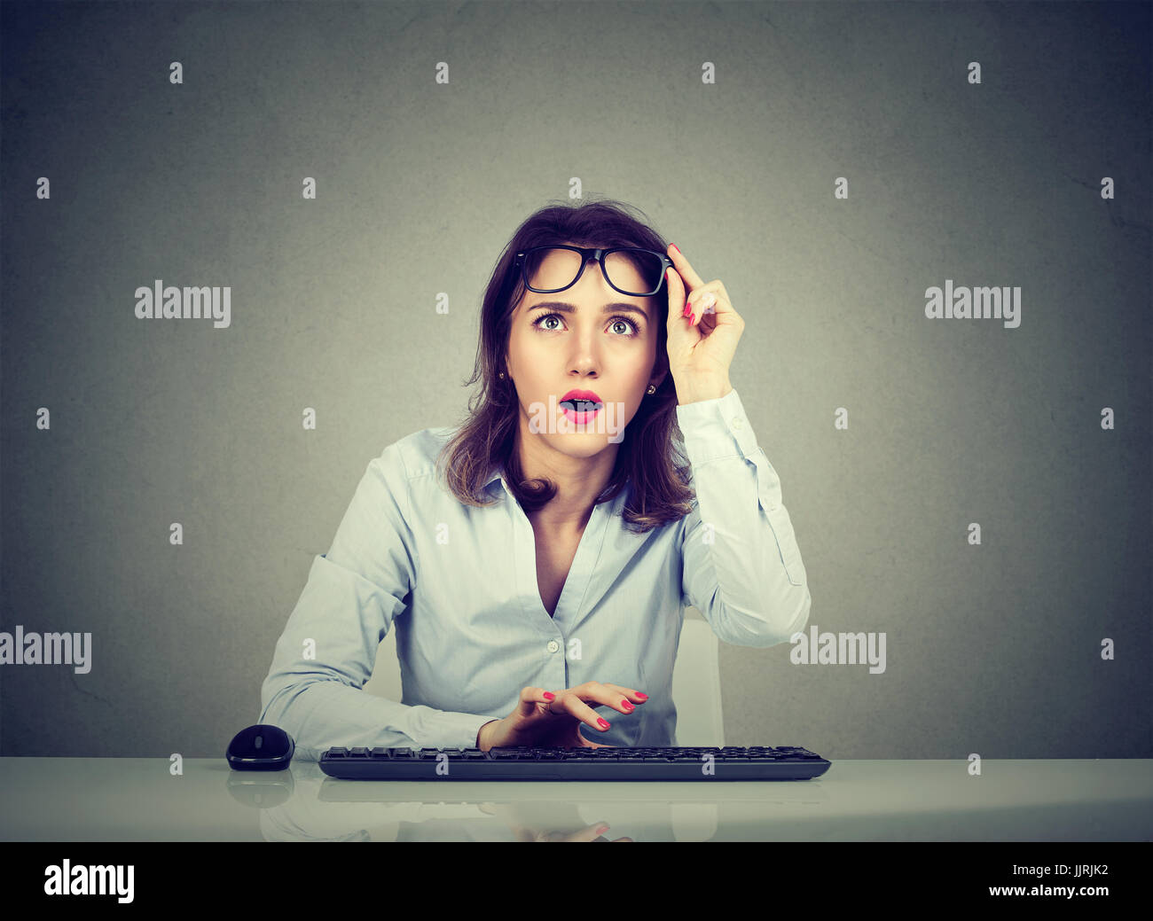Oh no! Surprised woman working on computer sitting at the table in her ...