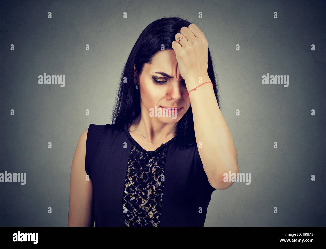 Sad regretful young woman looking down Stock Photo - Alamy