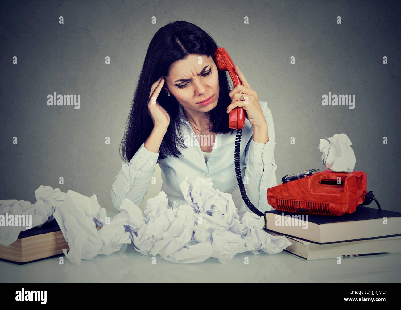 Desperate employee, upset woman talking on a phone in her office Stock ...