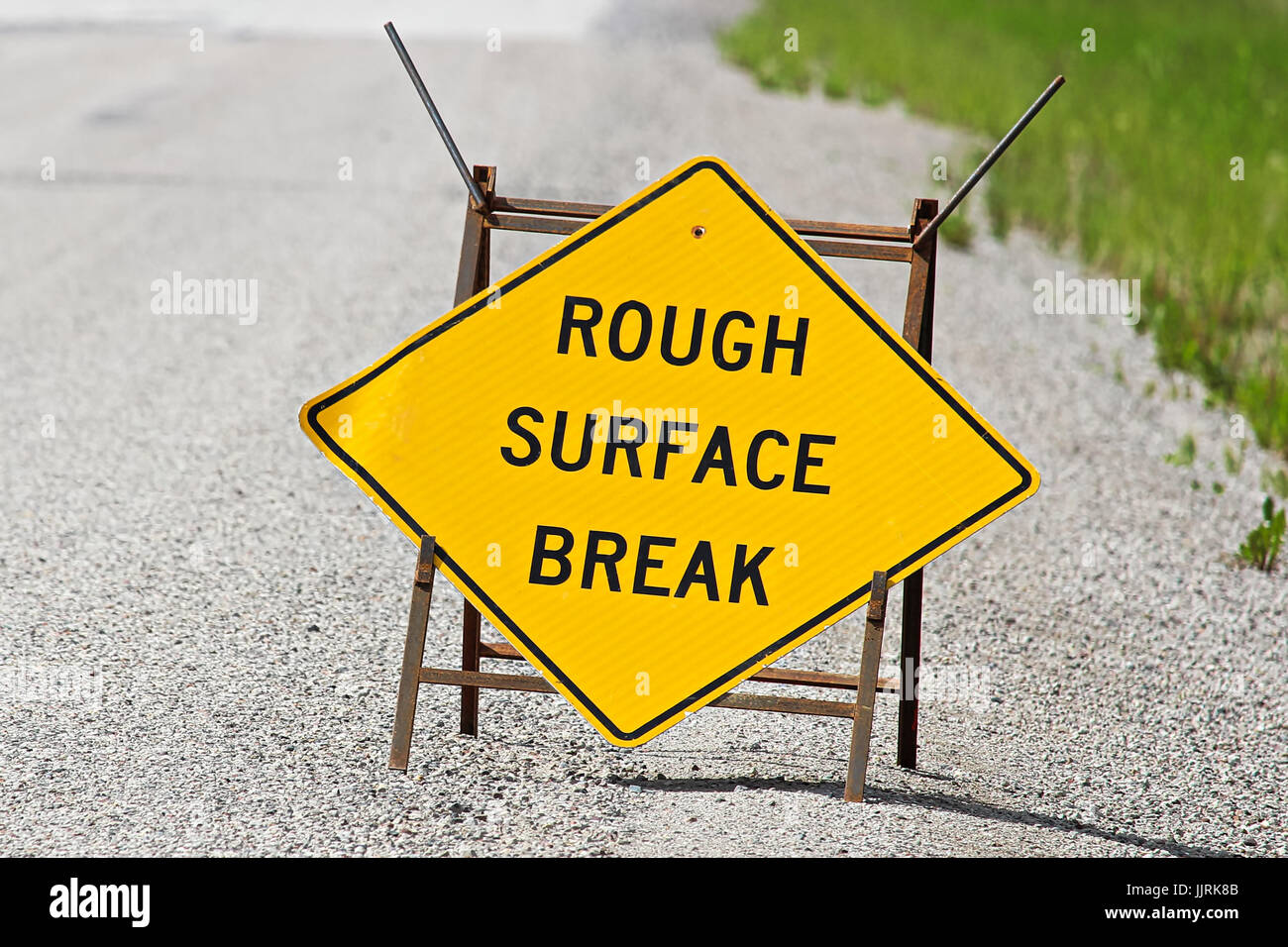 Closeup of a yellow rough surface break sign on pavement Stock Photo ...