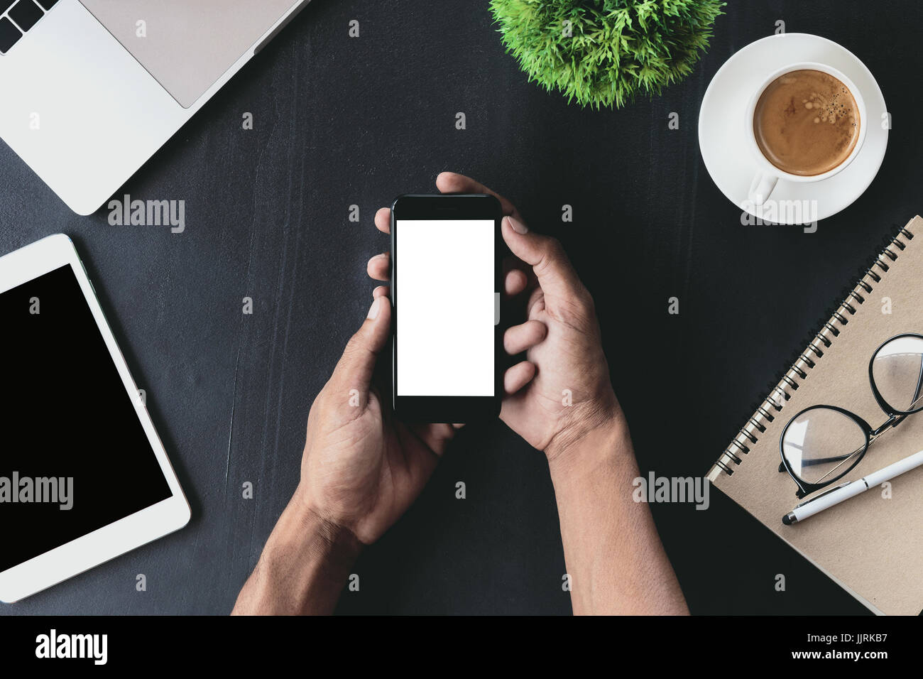 close-up on hand holding phone showing white screen on desk Stock Photo ...