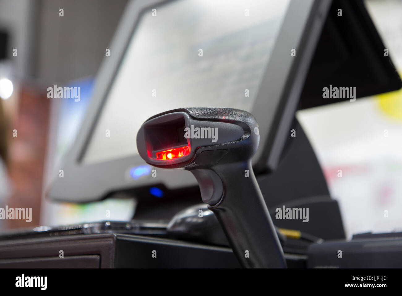 a hand held barcode scanner, scanning barcode ; shine red light;destop ...