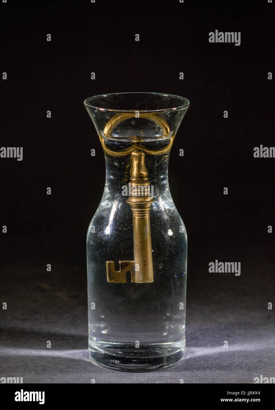 Vintage key in small vase of water Stock Photo - Alamy