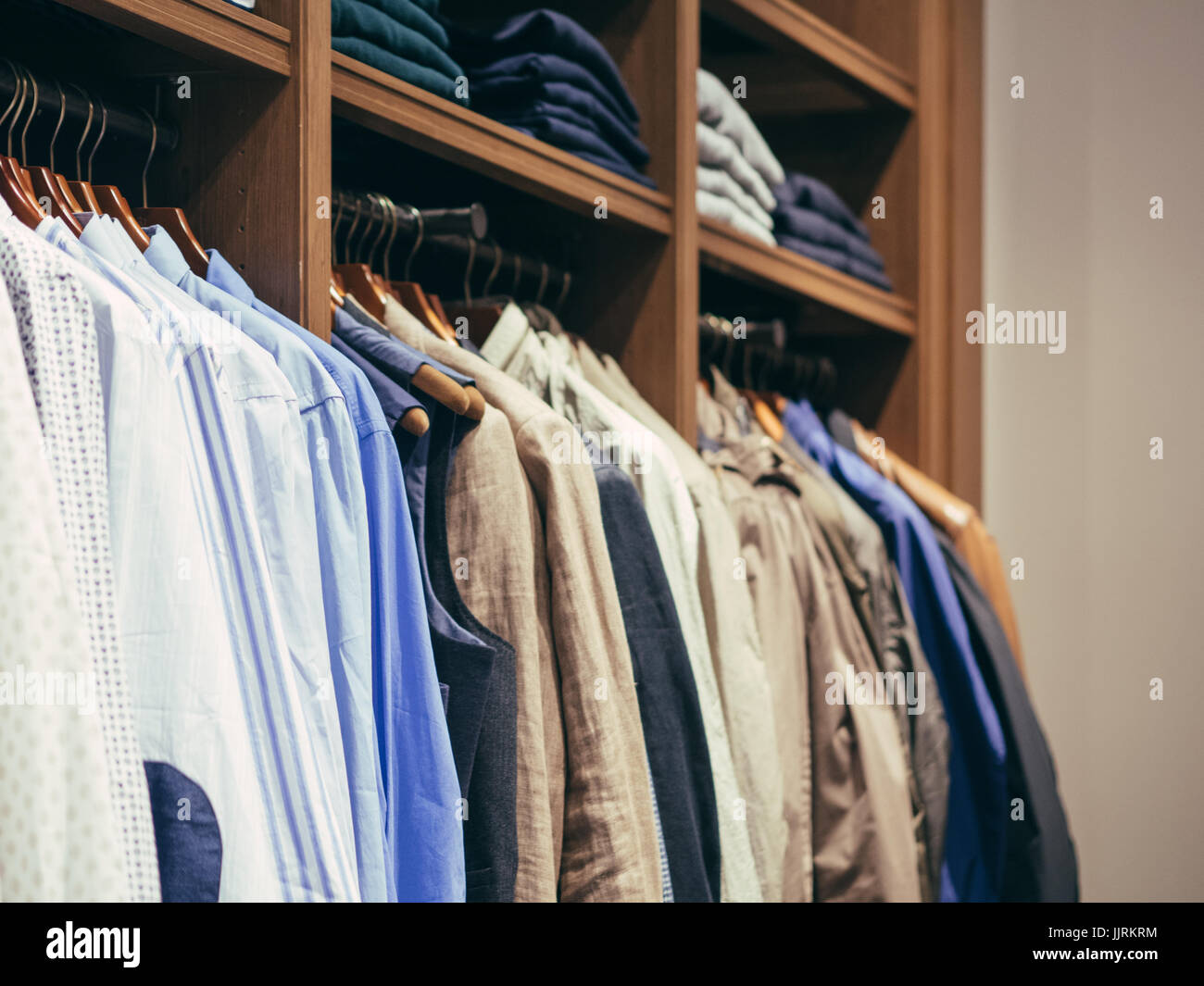 Close up view of man clothes hang in clothes store. Hangers with ...