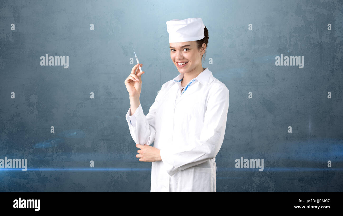 Beautiful medical woman doctor in uniform. Studio painted background ...
