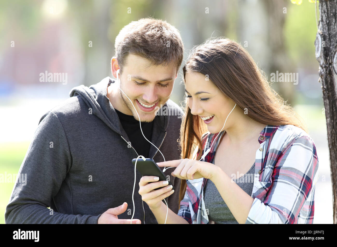 Two friends listening music together and selecting songs in a smart ...