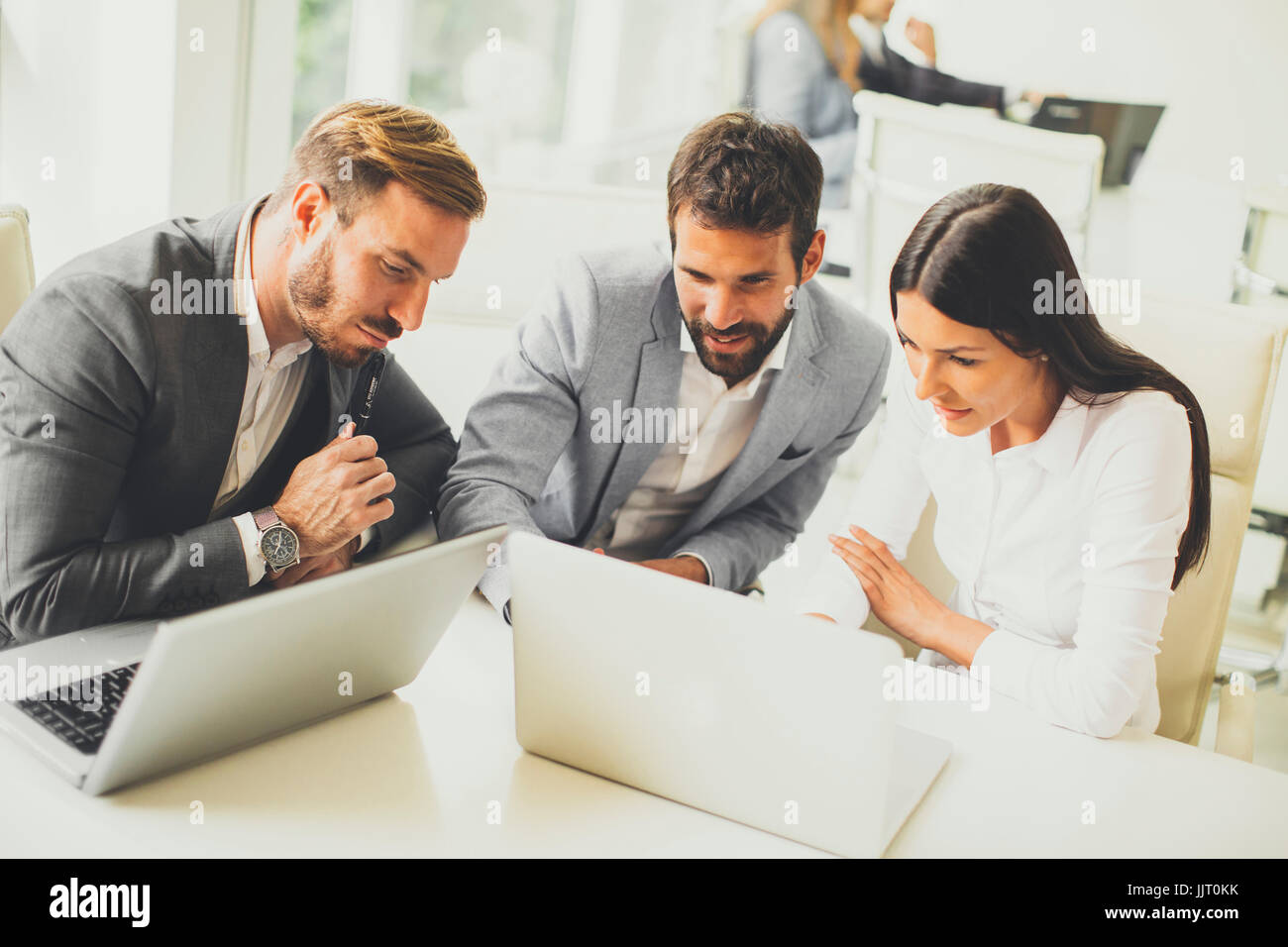 Young teamwork by the table in the office Stock Photo - Alamy