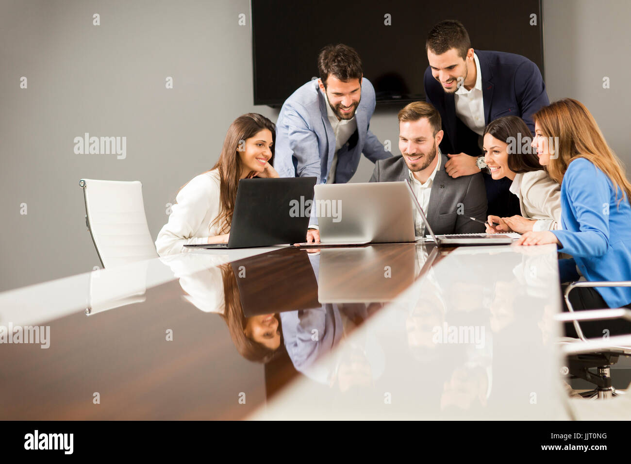 Young teamwork by the table in the office Stock Photo - Alamy
