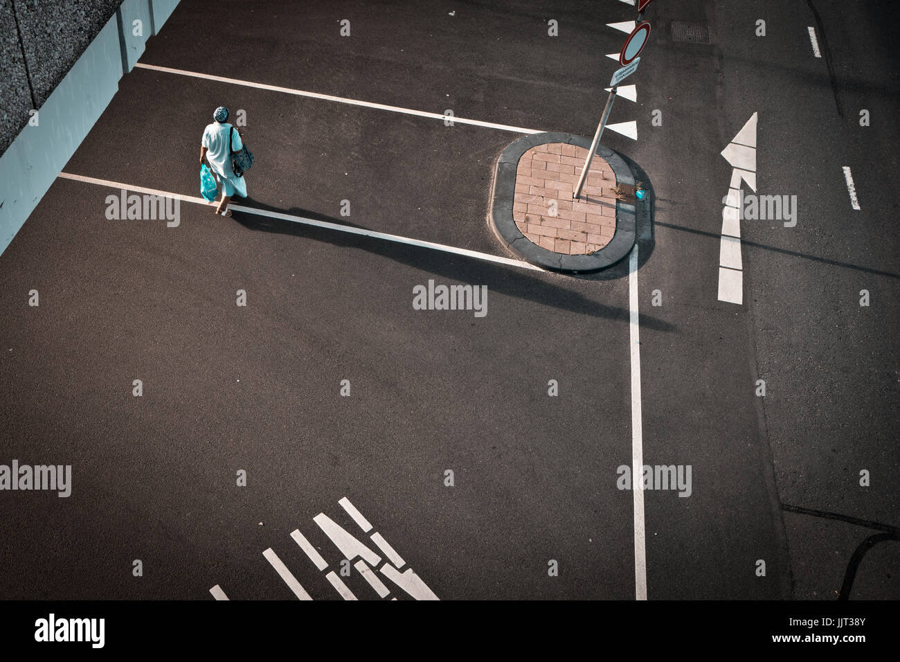 Rotterdam, single Person in urban street scenery with street markings ...
